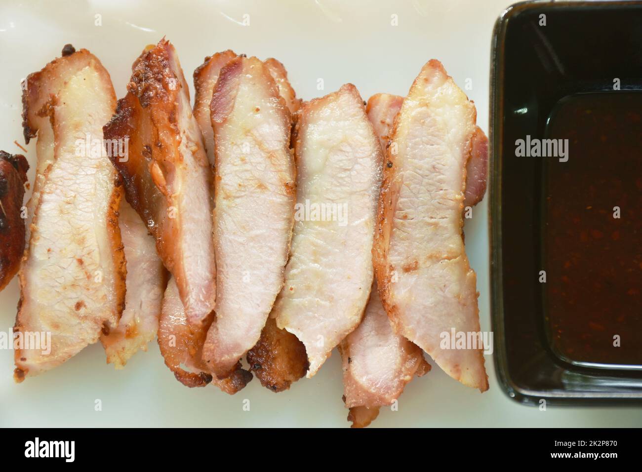 grilled pork neck slice on plate dipping spicy sauce Stock Photo - Alamy