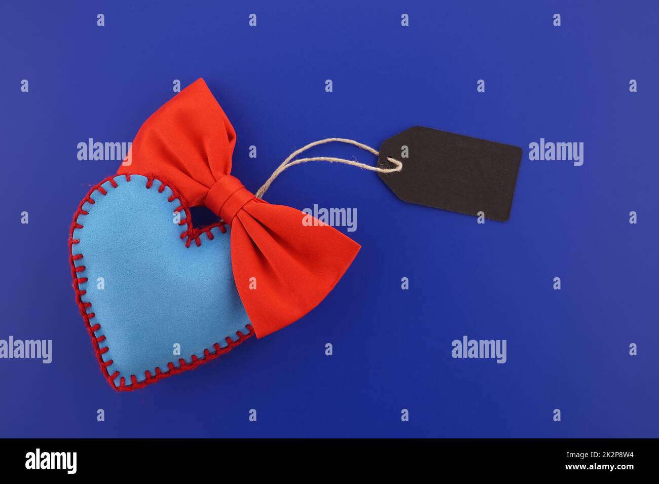 Blue felt heart with red bow tie and blank label tag Stock Photo - Alamy