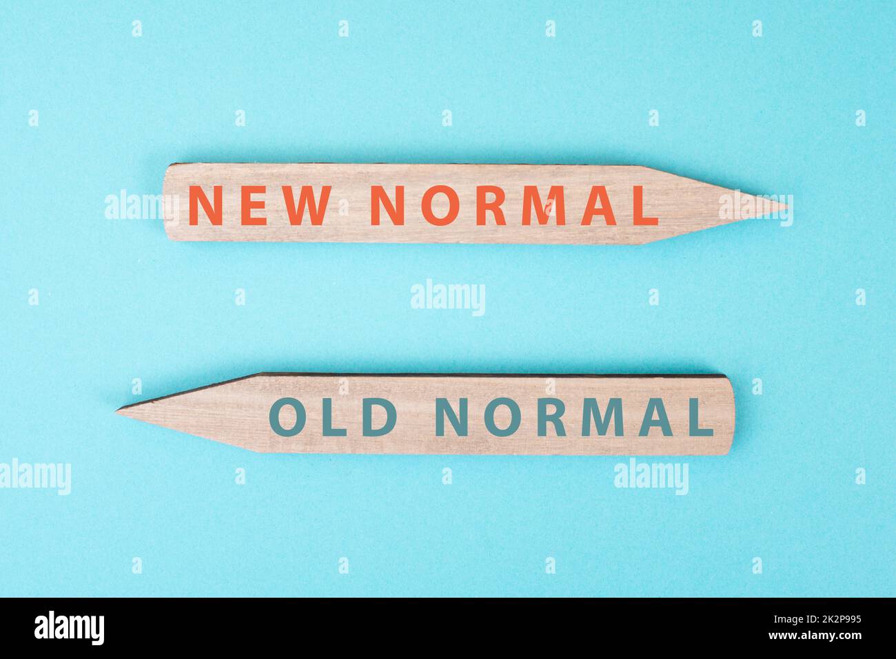 The words new and old normal are standing on wooden arrows ...