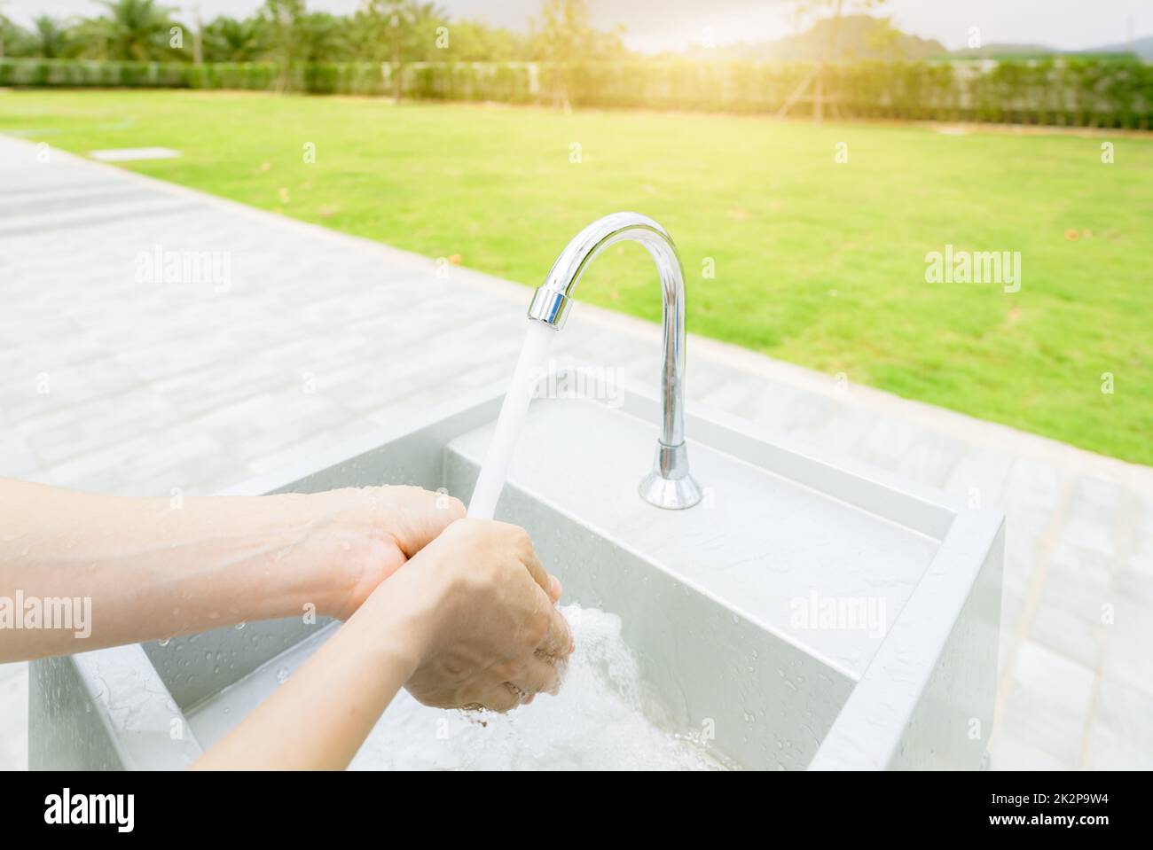Woman washing hands with tap water under faucet at white sink. Washing ...