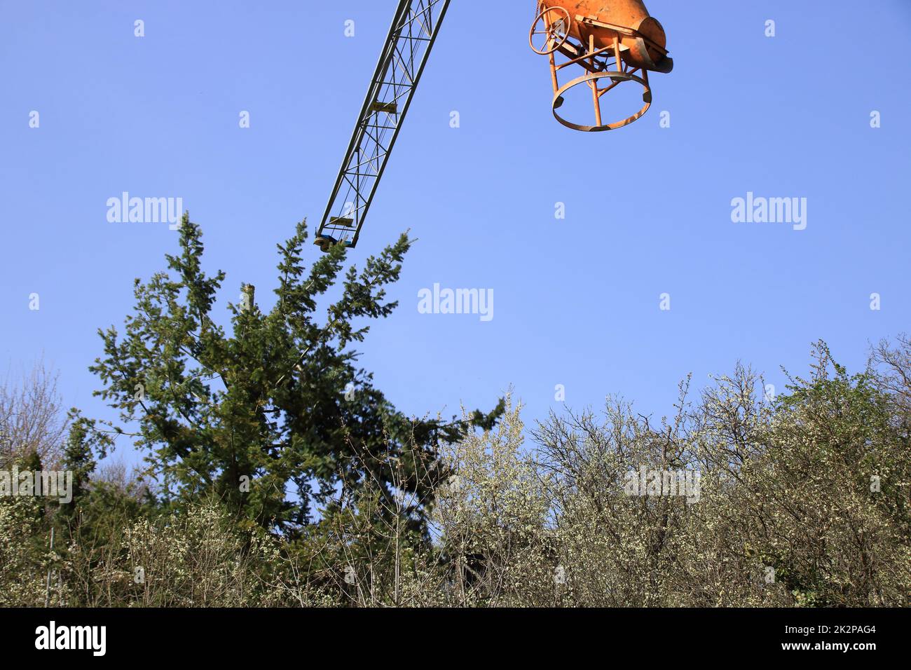 The boom of a construction crane snaps the top of a tree Stock Photo ...