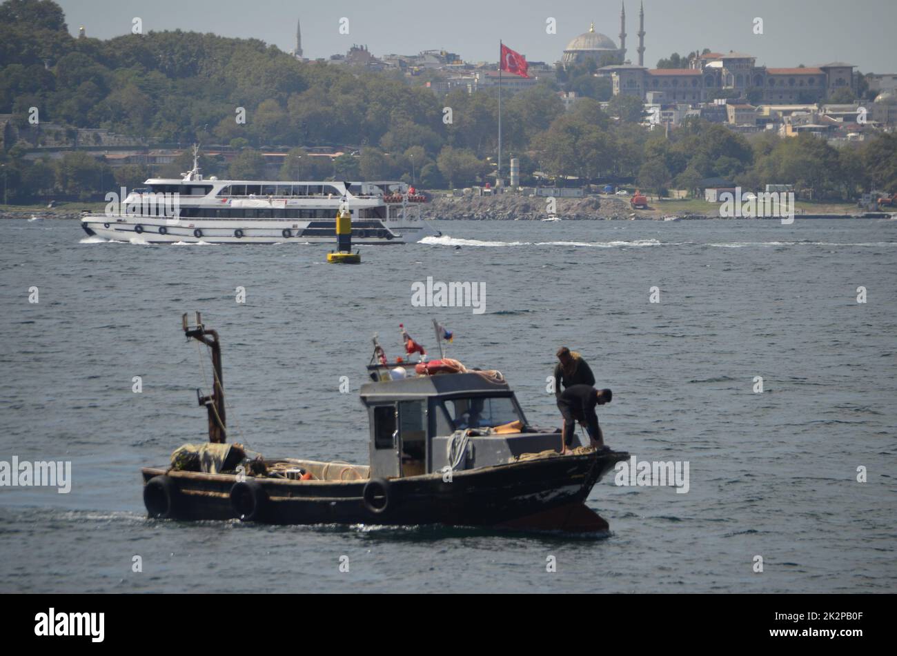 Fishing boat, fisherman, passenger boat and cityscape, Istanbul, Turkey ...