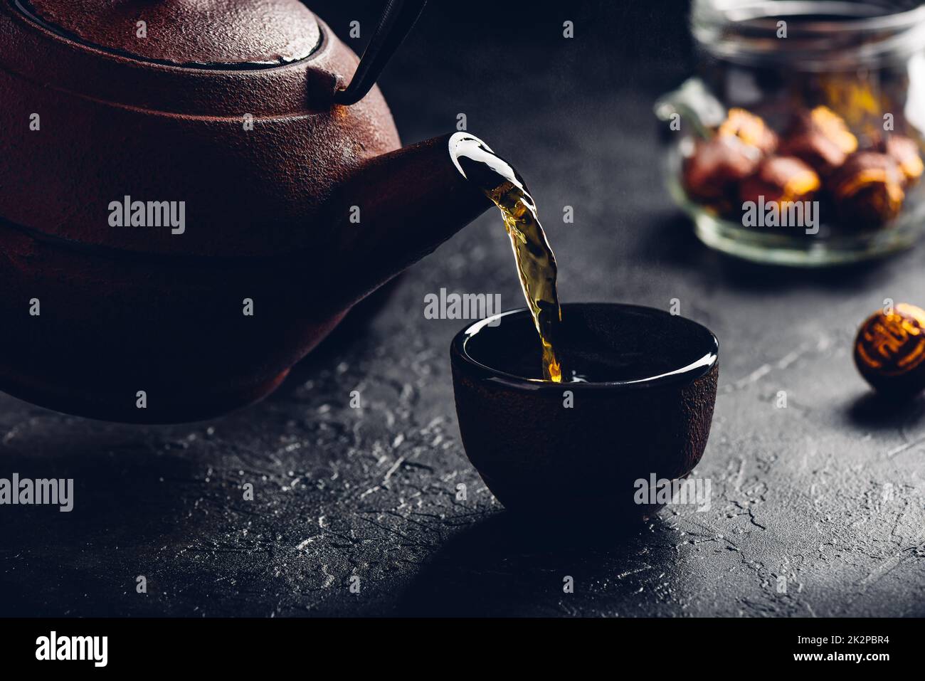 Pouring ready red tea into tea bowl Stock Photo - Alamy