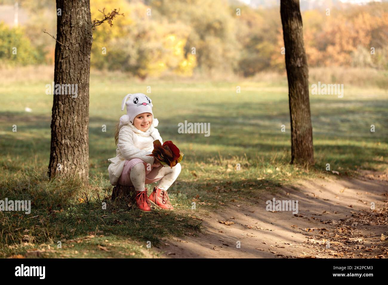 baby girl pick up a bouquet of yellow leaves on autumn day Stock Photo ...