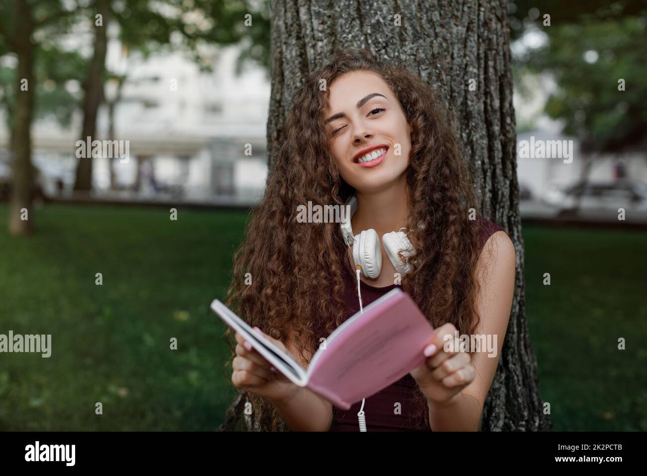 Teenager sitting under tree hi-res stock photography and images - Alamy
