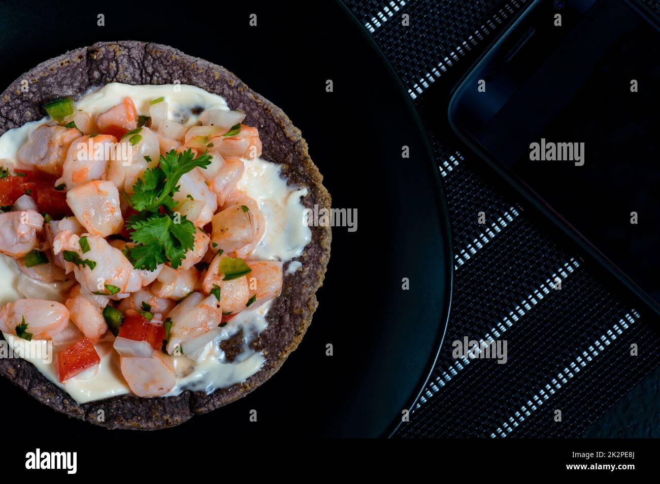 Red shrimp ceviche and blue corn tostada with mobile phone Stock Photo ...