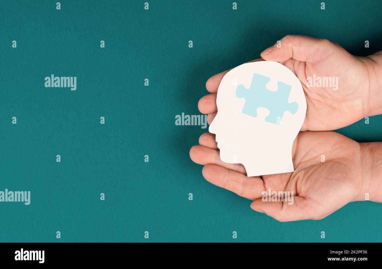 Holding a head with a puzzle piece, mental disease like Autism ...