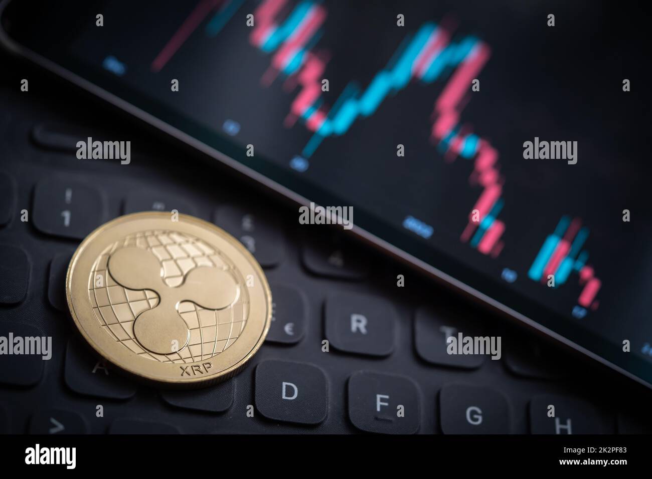 Ripple cryptocurrency coin with candle stick graph chart, laptop ...