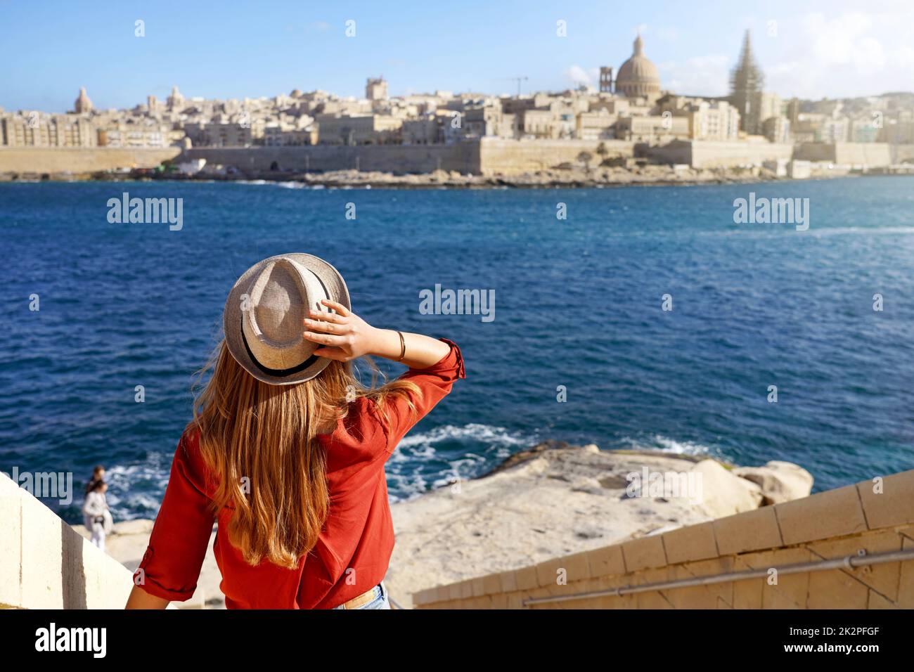Beautiful young woman with hat descends stairs in Malta towards ...
