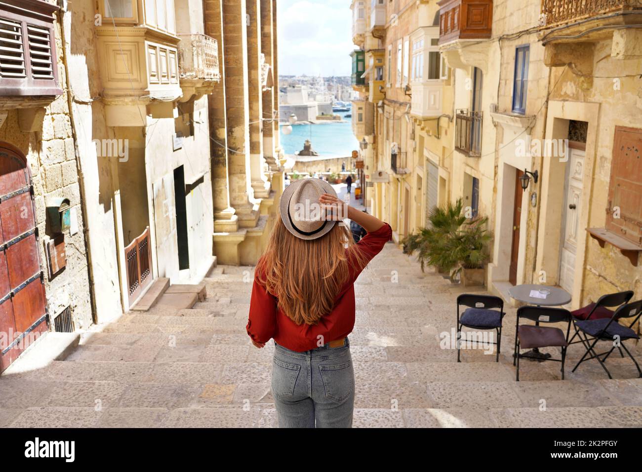 Holidays in Malta. Back view of traveler woman descends stairs in the ...