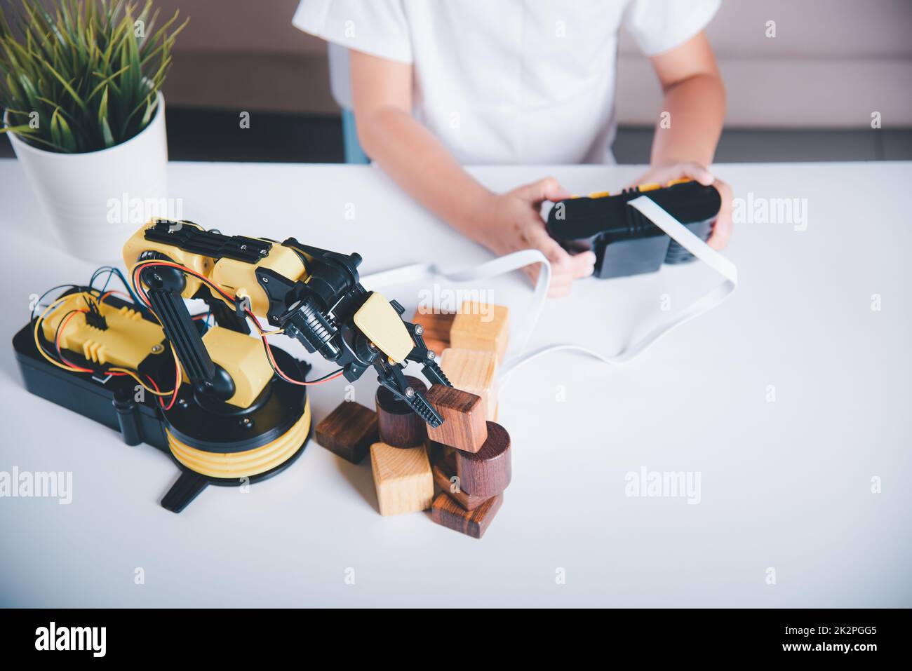 Happy Asian little kid boy using remote control playing robotic machine ...