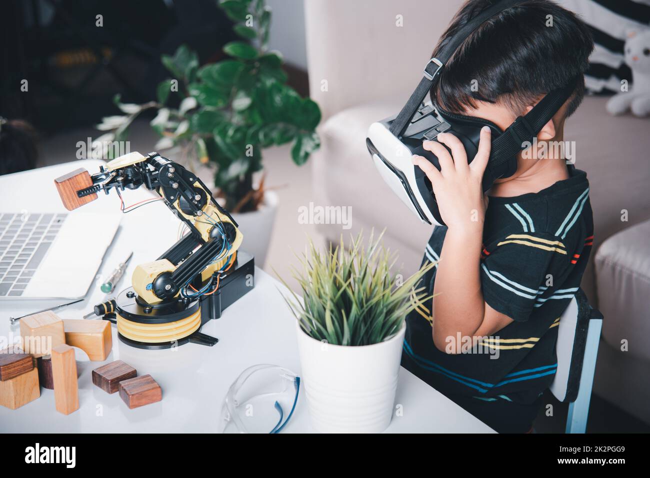 Asian kid boy using VR glasses on robotic arm in workshop Stock Photo ...