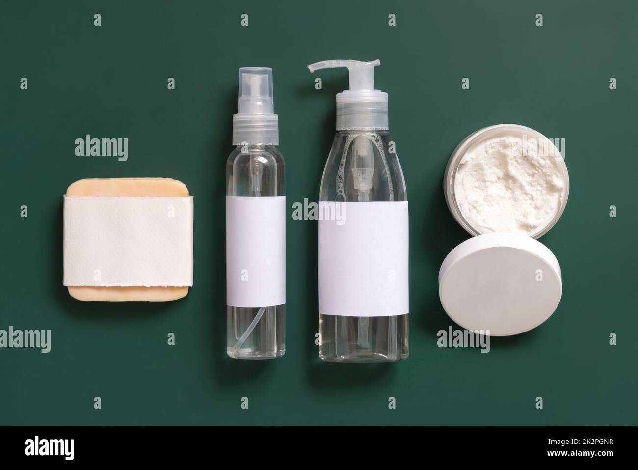 Homemade Cosmetics in plastic tubes and bottles on dark green top view ...