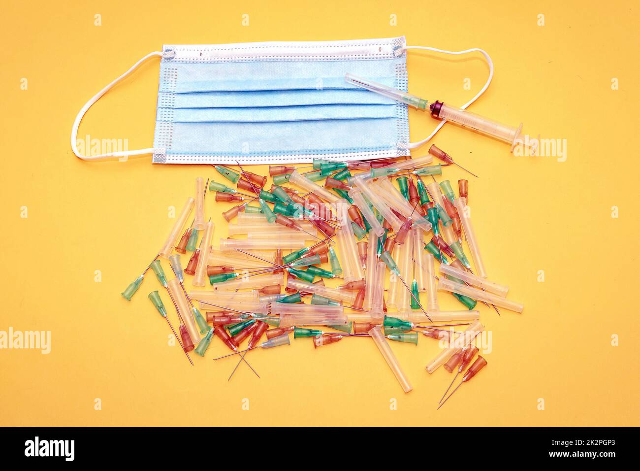 Face mask with used injection and needles pile Stock Photo - Alamy