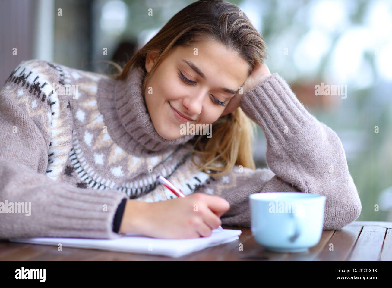 Woman taking notes in a terrace in winter Stock Photo - Alamy
