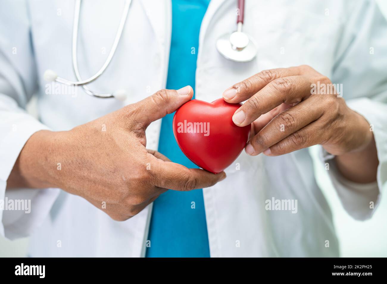 Doctor holding a red heart in hospital ward, healthy strong medical ...