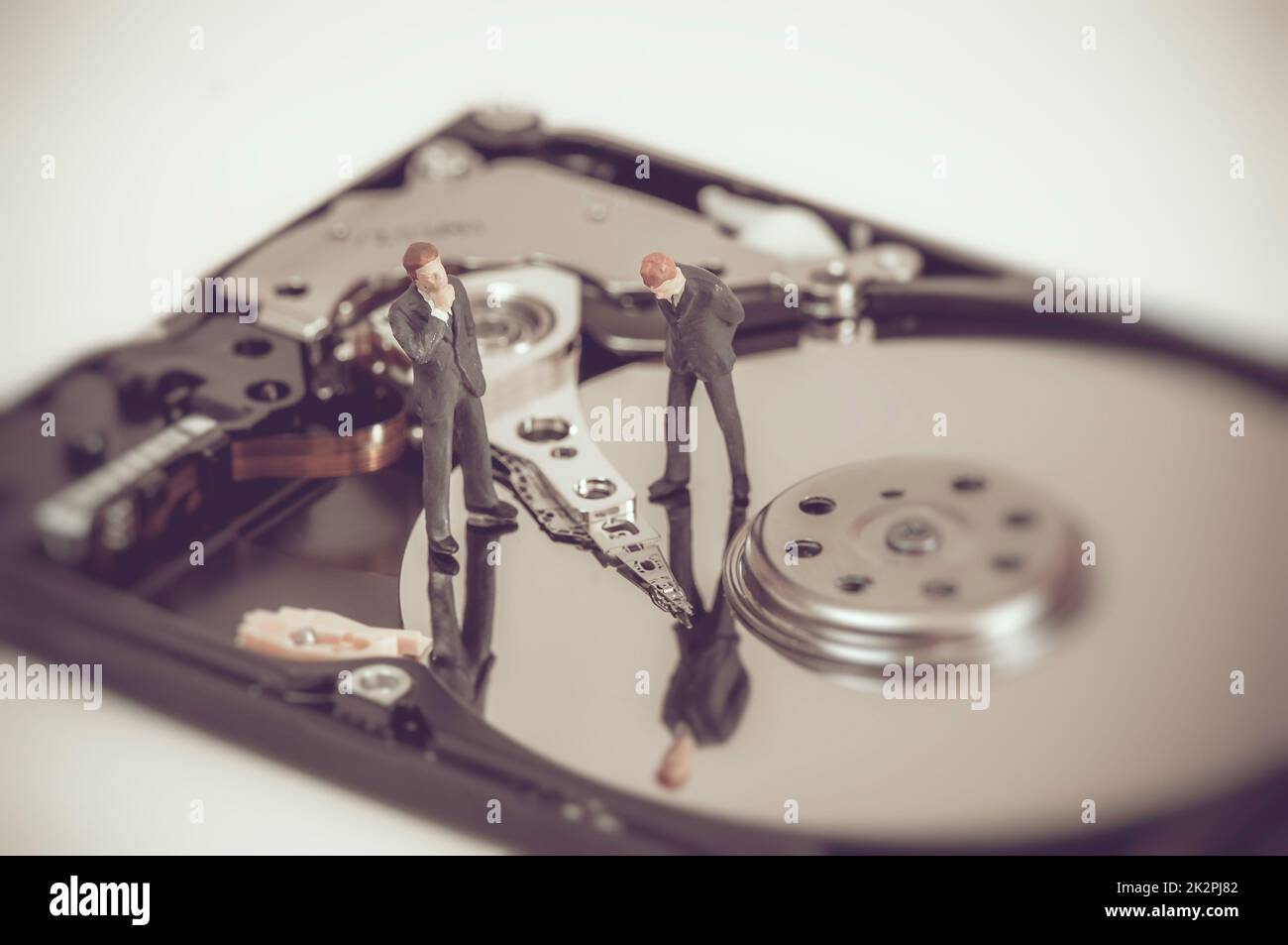 Miniature business people on top of hard drive. Business concept Stock ...