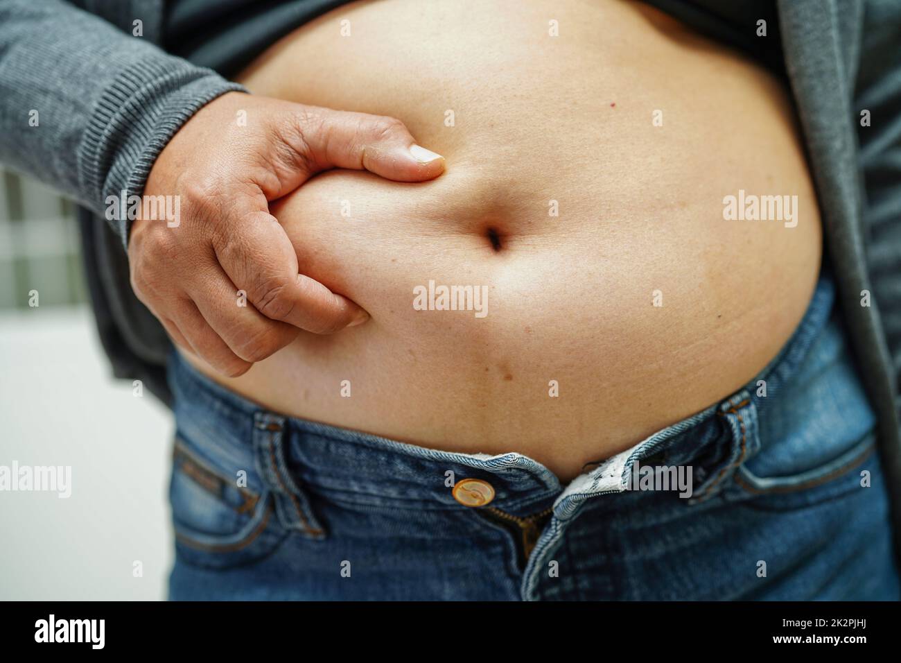 Overweight asian woman use hand to squeeze fat belly big size ...
