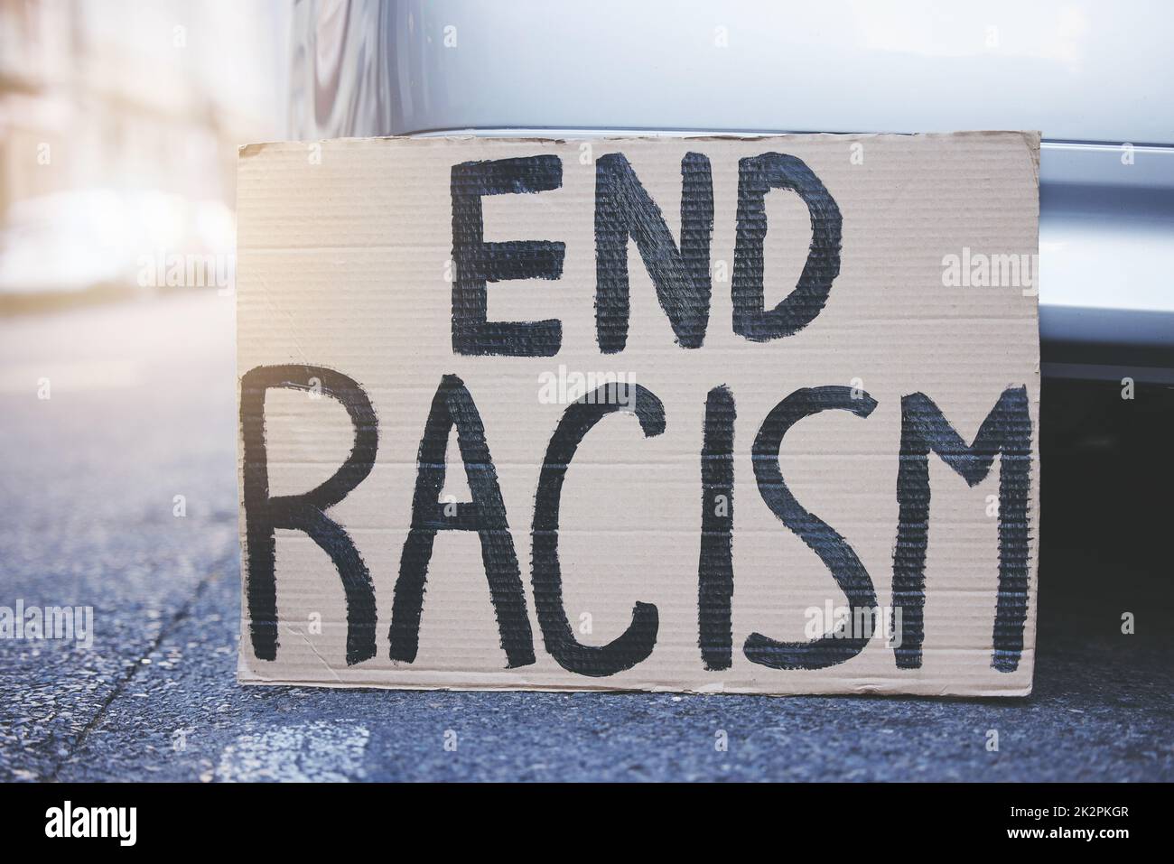 End racism placard, sign and poster for protest in an urban street ...