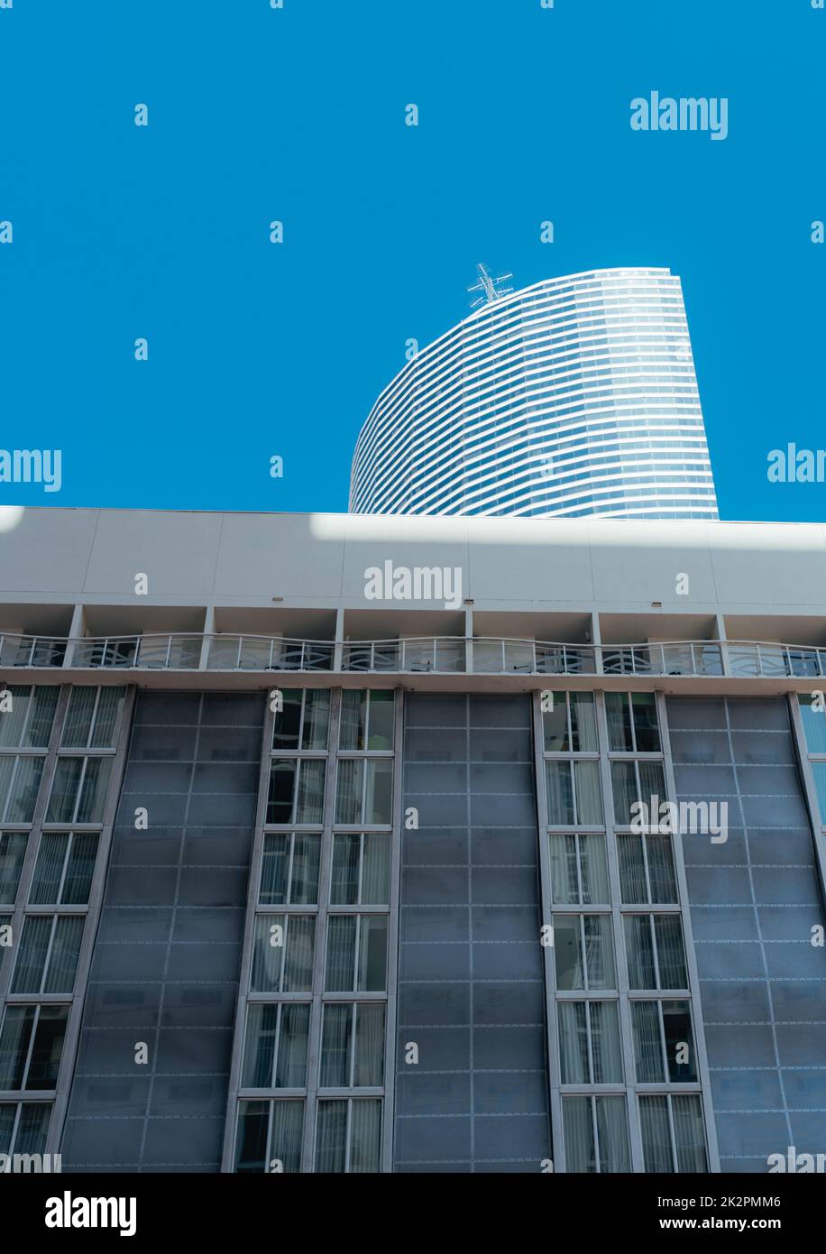 A low angle of the Chifley tower behind a building under a blue sky ...