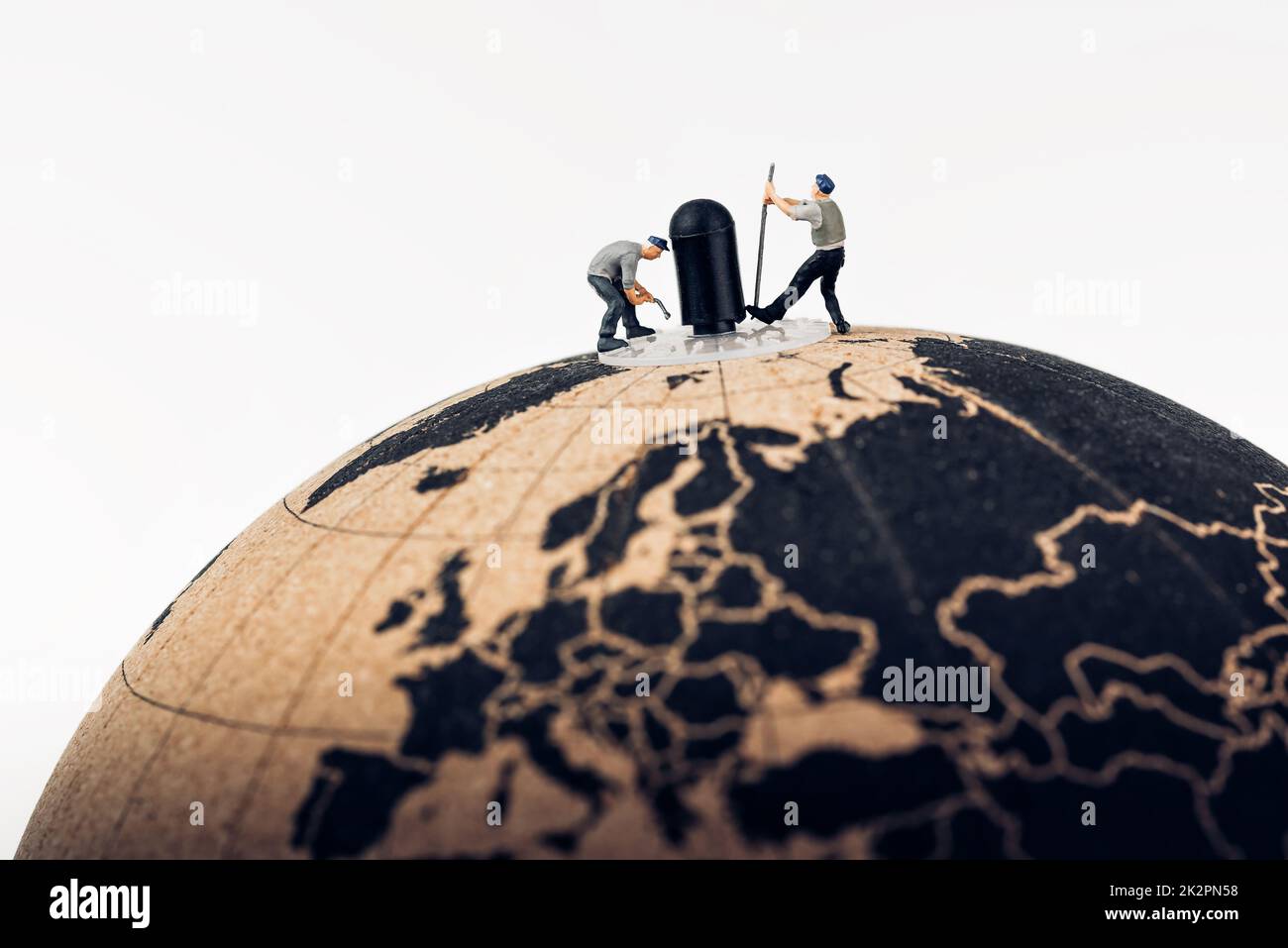 Worker with crowbar moving globe axis Stock Photo - Alamy