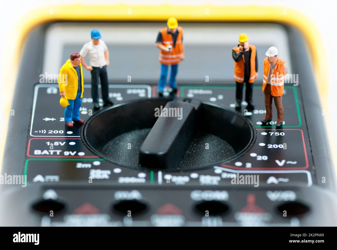 Team of miniature workers on top of multimeter. Macro photo Stock Photo ...