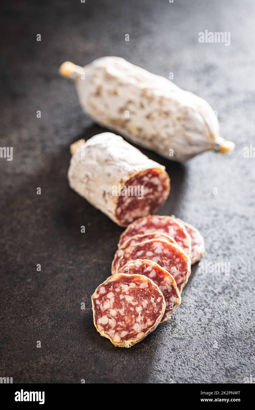 Traditional sausage with white mold. Dried pork salami on black table ...
