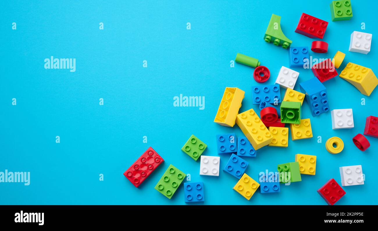 Scattered parts of a plastic children's designer, top view. Yellow blue ...