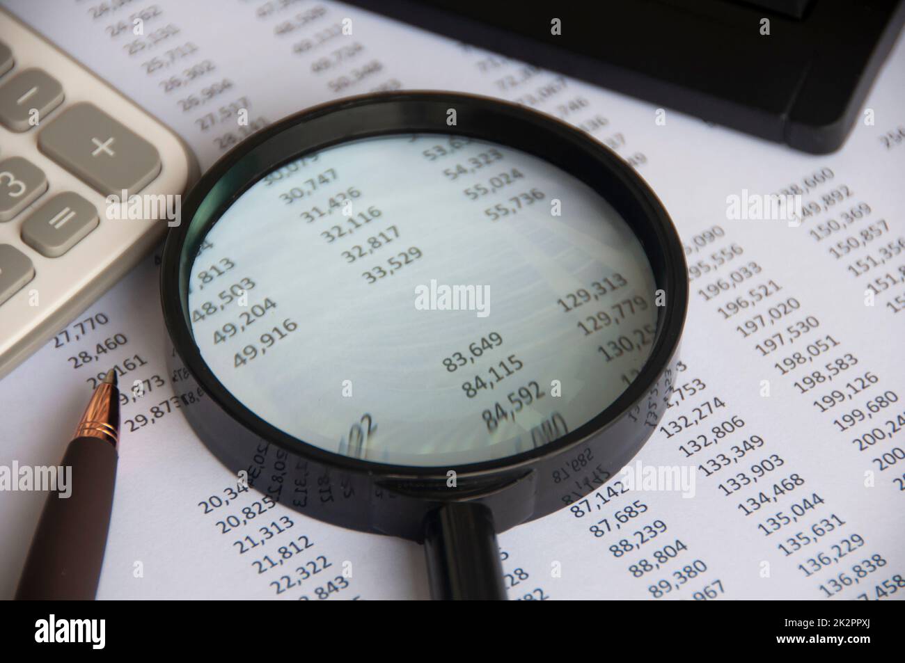 Business analysis concept - magnifying glass with calculator and number ...