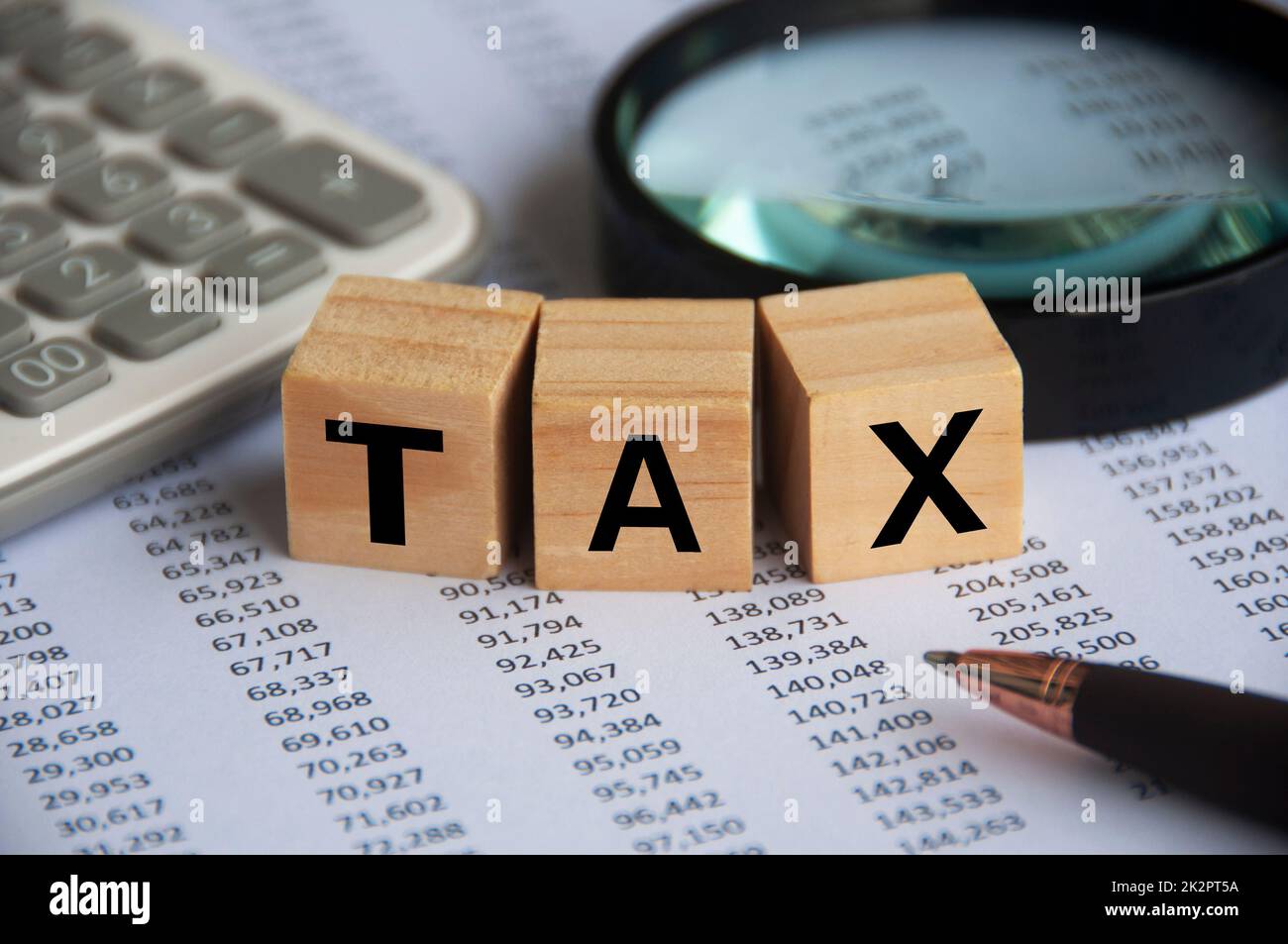 Tax word on wooden blocks with magnifying glass, calculator and number ...