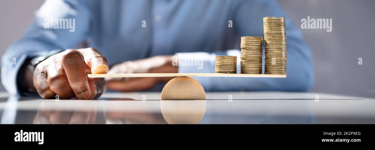 Man Holding Two Coin Stacks Stock Photo - Alamy
