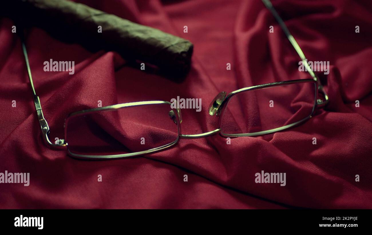 CIgar and glasses on red satin shallow depth of field Stock Photo - Alamy