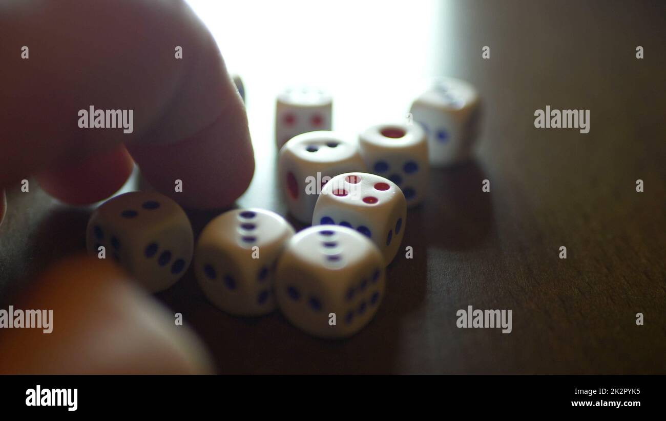 Finger tapping on table with dice on shallow depth of field Stock Photo ...