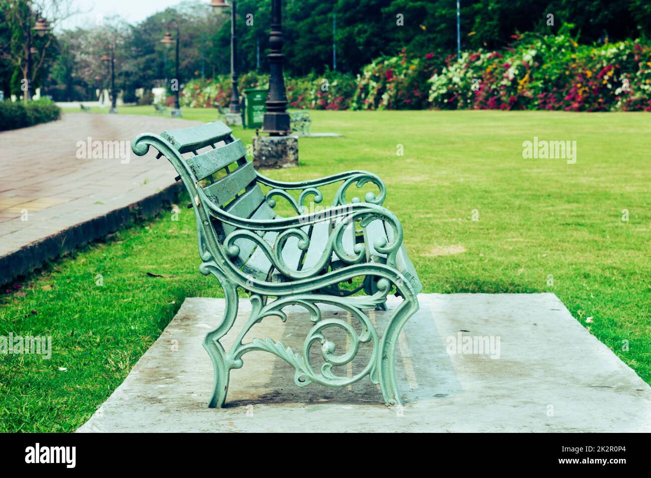 Side view of a garden chair, outdoors next to a footpath road and green ...
