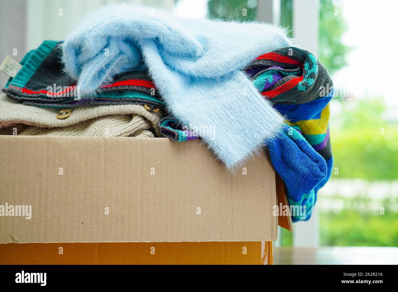 Clothes donations in cardboard box for volunteer Stock Photo - Alamy