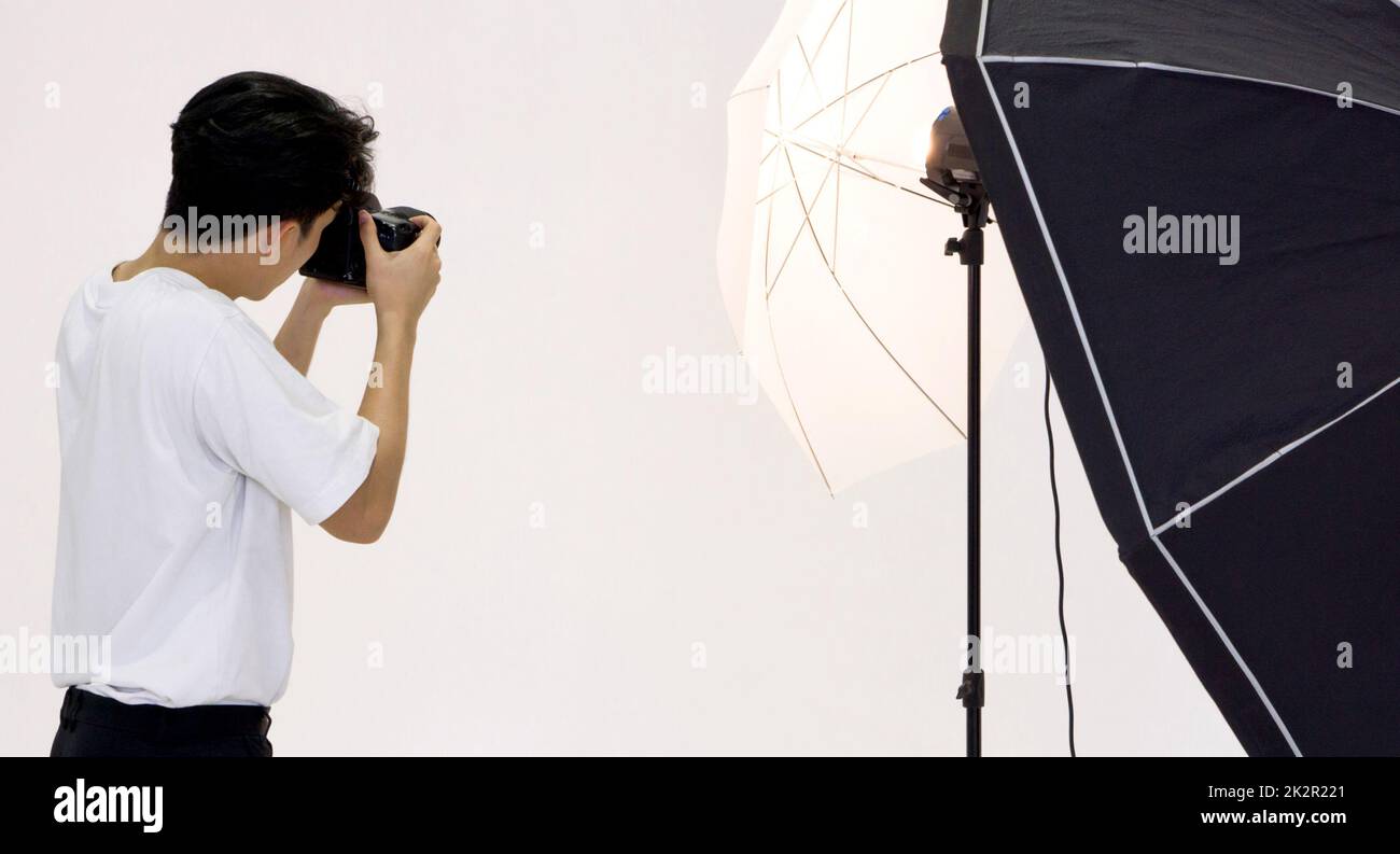 Asian photographer looks through the viewfinder while shooting with the ...