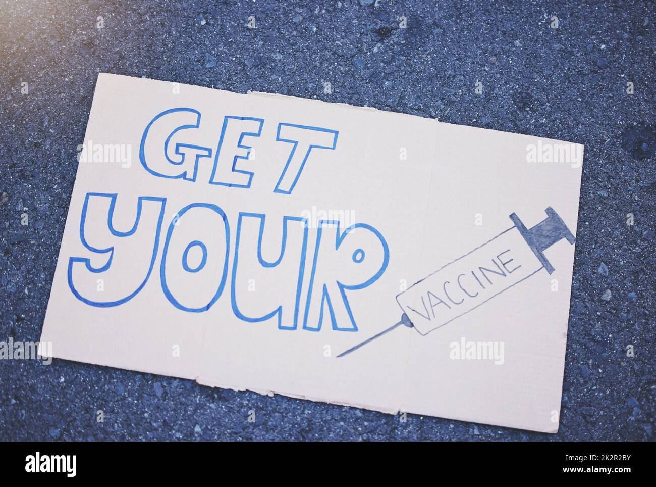 Covid, vaccine and poster with a sign on the ground outside during the ...