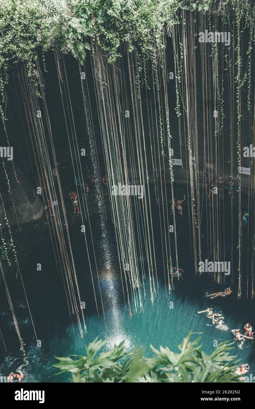 A vertical shot of a rainbow in Cenote Ik Kil Yucatan State, Mexico ...