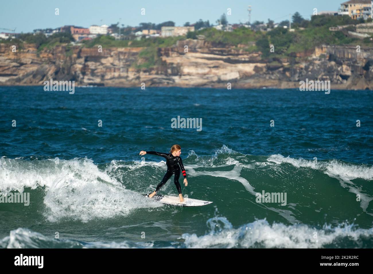 A surfer standing on the shortboard and catching waves, scattering ...