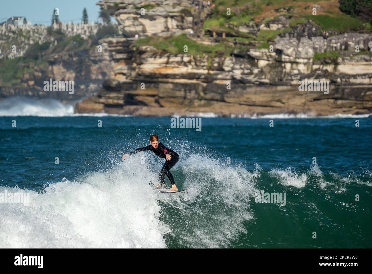 A surfer standing on the shortboard and catching waves, scattering ...