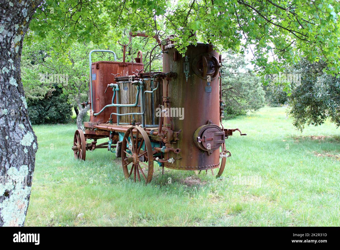 An old brown stream machine on grass field in the Garden with trees and ...
