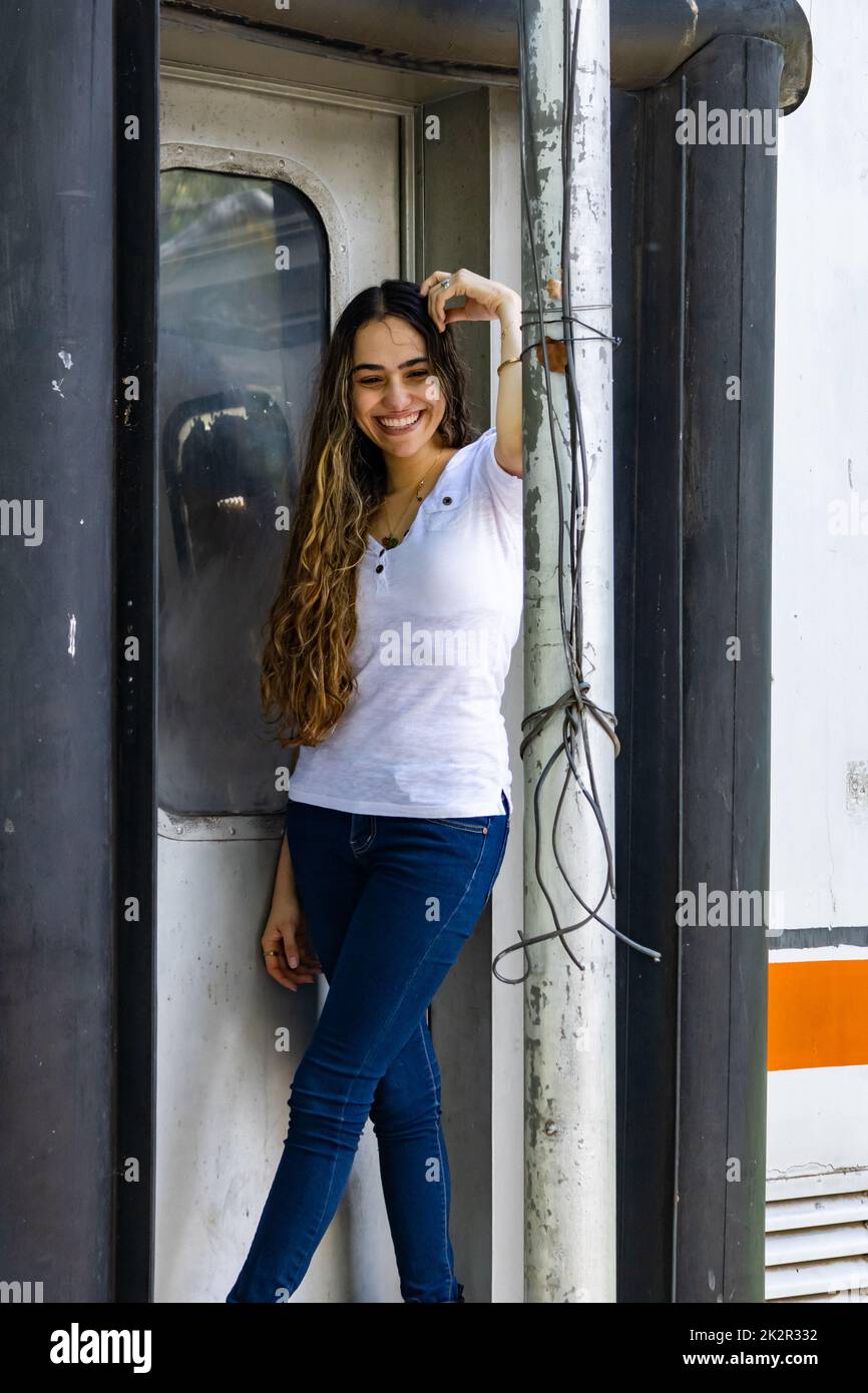 The vertical view of a casually dressed happy female Hispanic model ...