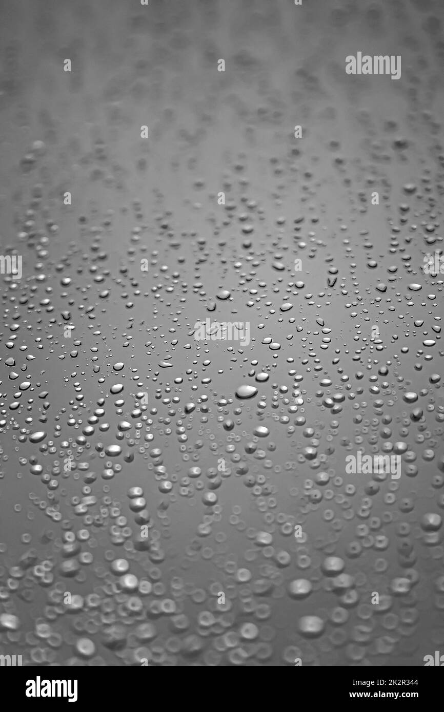 A vertical greyscale shot of water drops on a glass Stock Photo - Alamy
