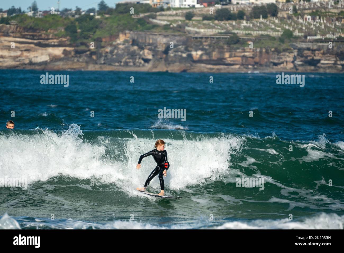 A surfer standing on the shortboard and catching waves, scattering ...