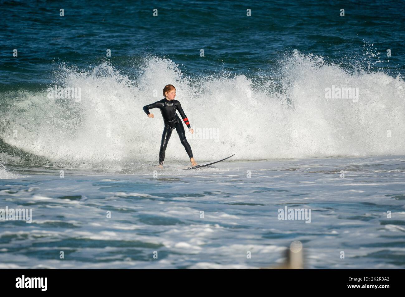 A surfer standing on the shortboard and catching waves, scattering ...