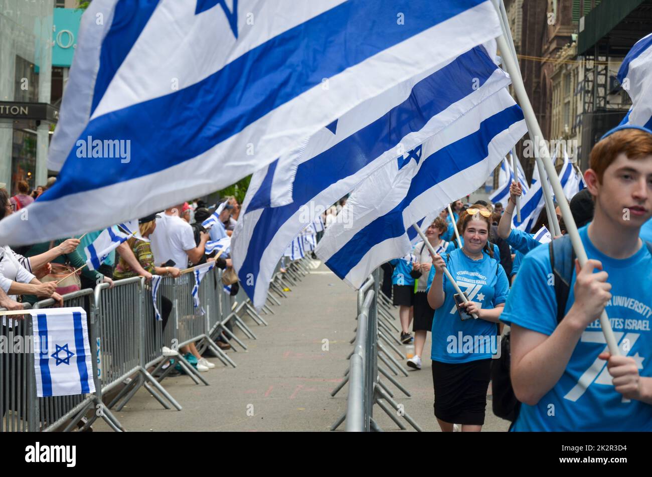 Several people with flags walking on the Annual Israel Day Parade along ...