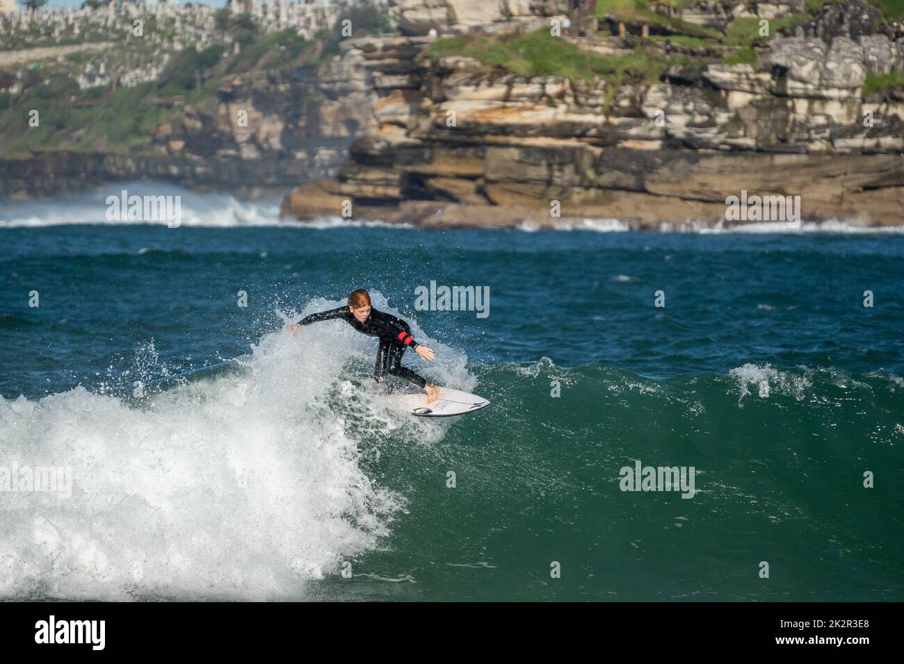 A surfer standing on the shortboard and catching waves, scattering ...