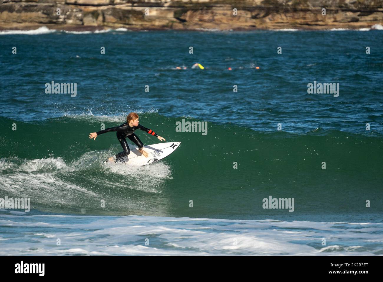 A surfer standing on the shortboard and catching waves, scattering ...