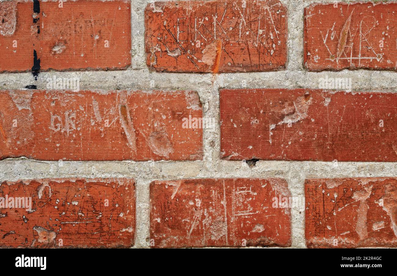 Signature wall. A photo of brick wall of an old school with a lot of ...