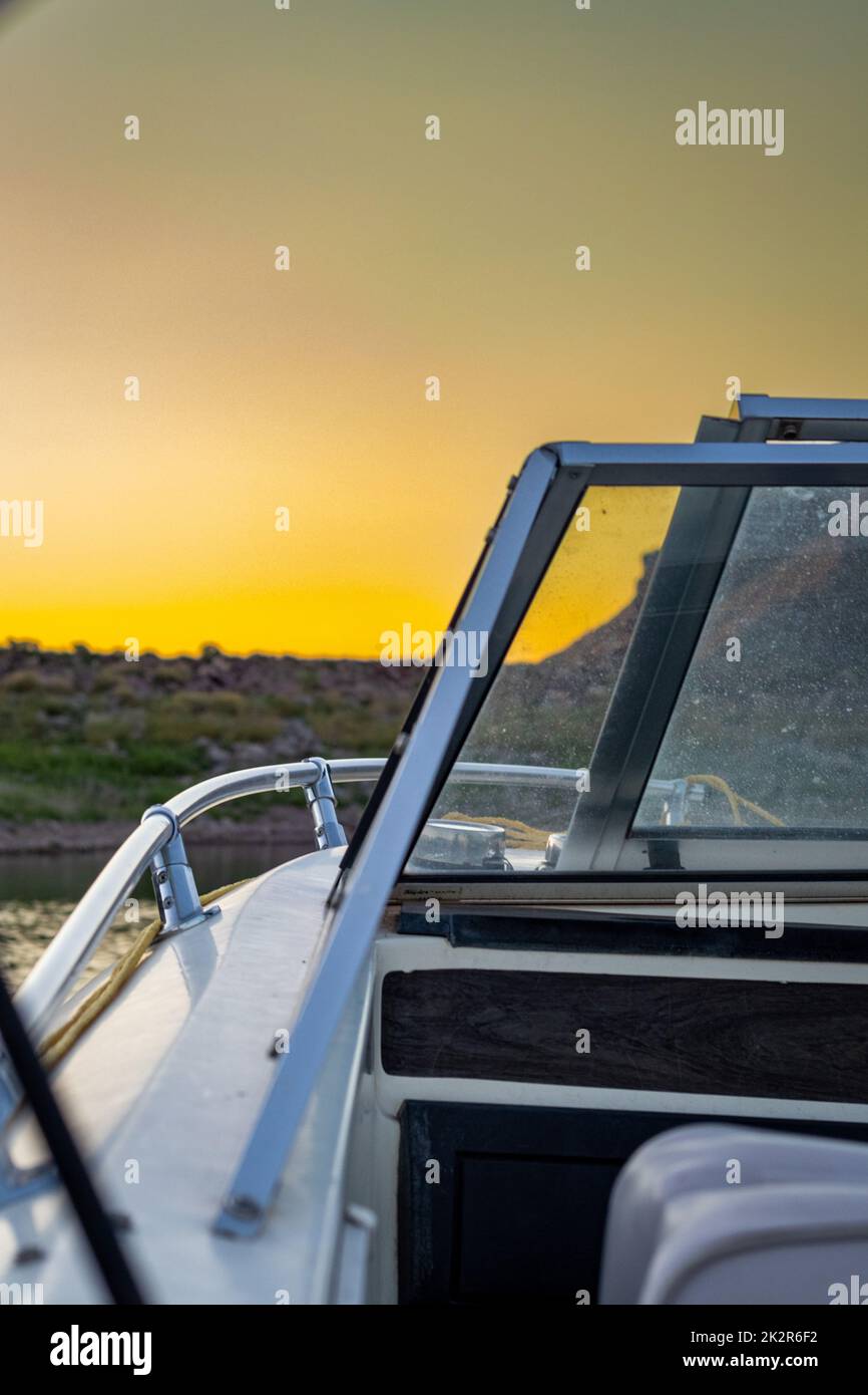 A scenic shot from inside a boat with the golden sunset on the horizon ...
